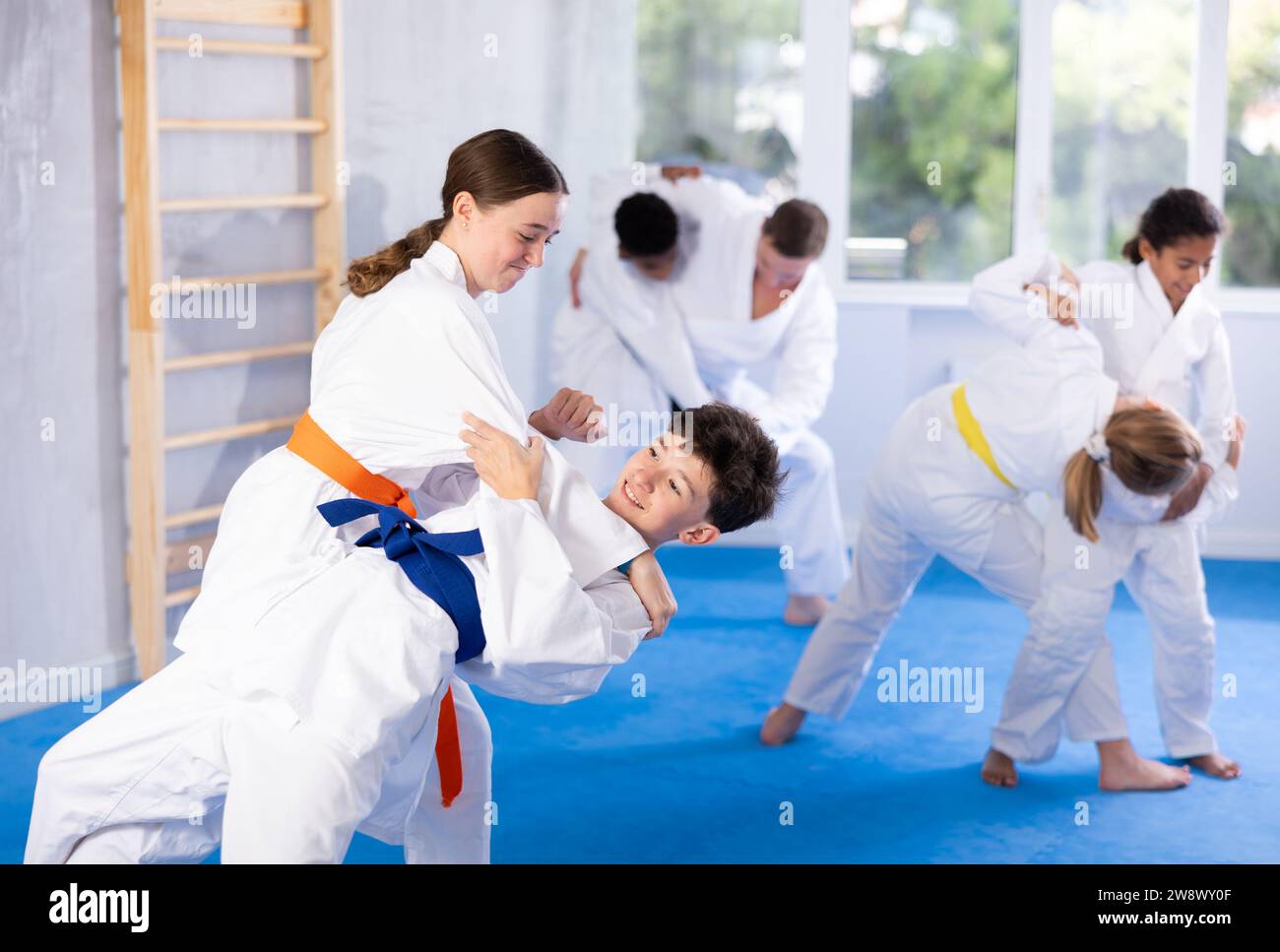 Teenage girl practicing fighting techniques during martial arts ...