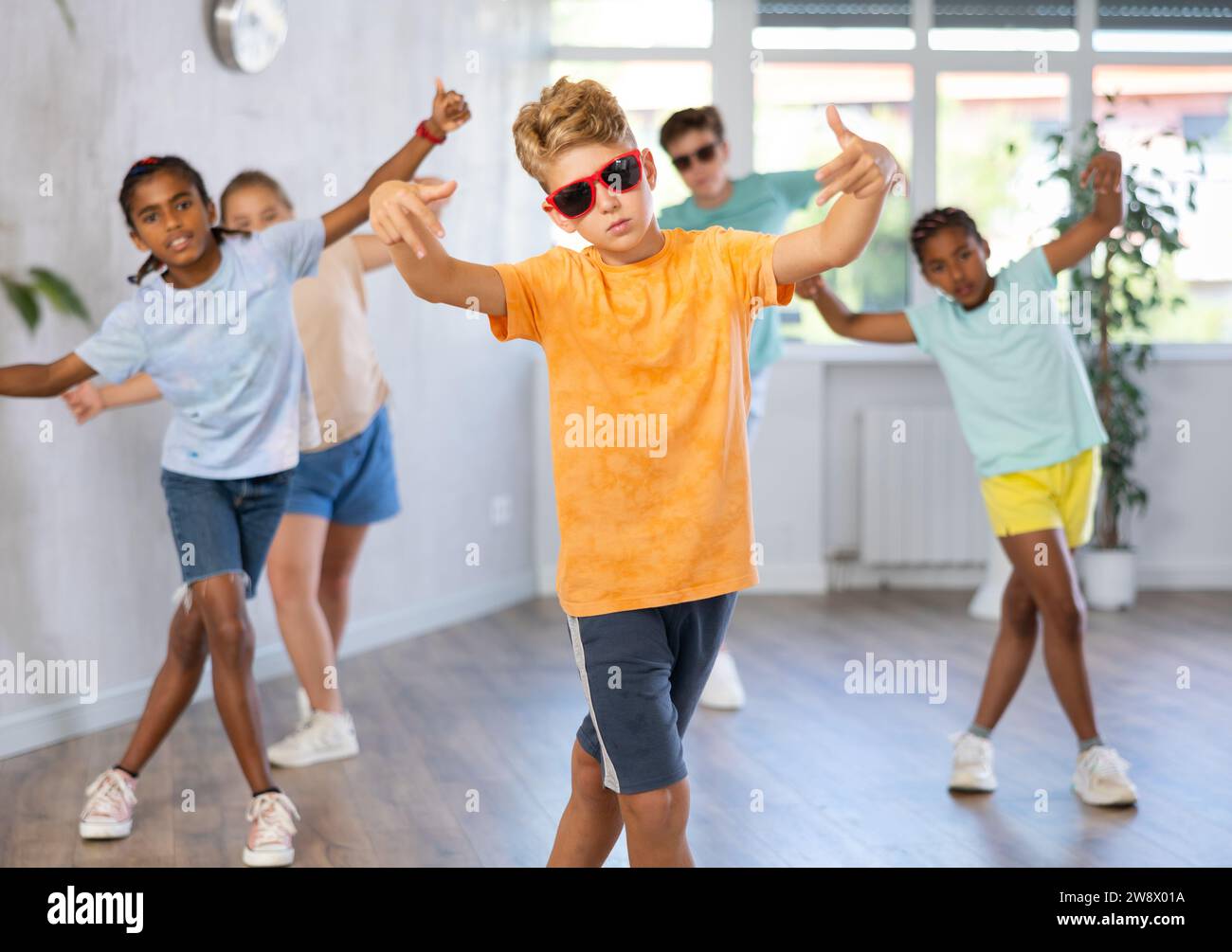 Preteenage boy and girl in sunglasses dancer practicing active dance in ...
