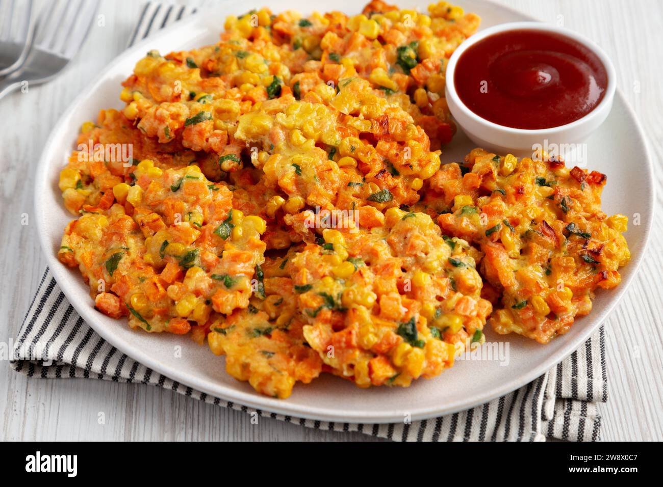 Homemade Carrot Corn Fritters with Ketchup on a Plate, side view. Close ...