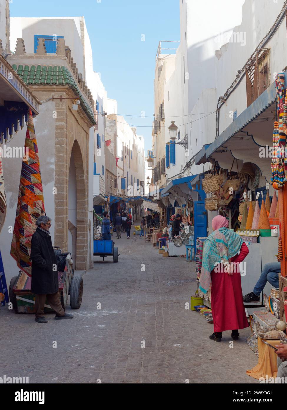Local traders stand outside their stores in a colourful street in the ...