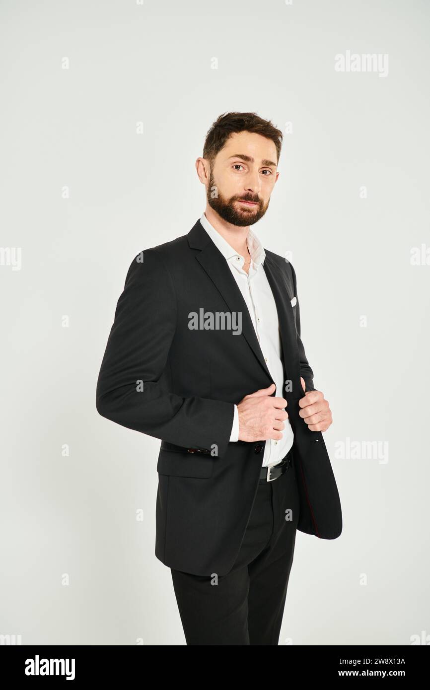 sharp-dressed charismatic businessman in black formal wear looking at ...