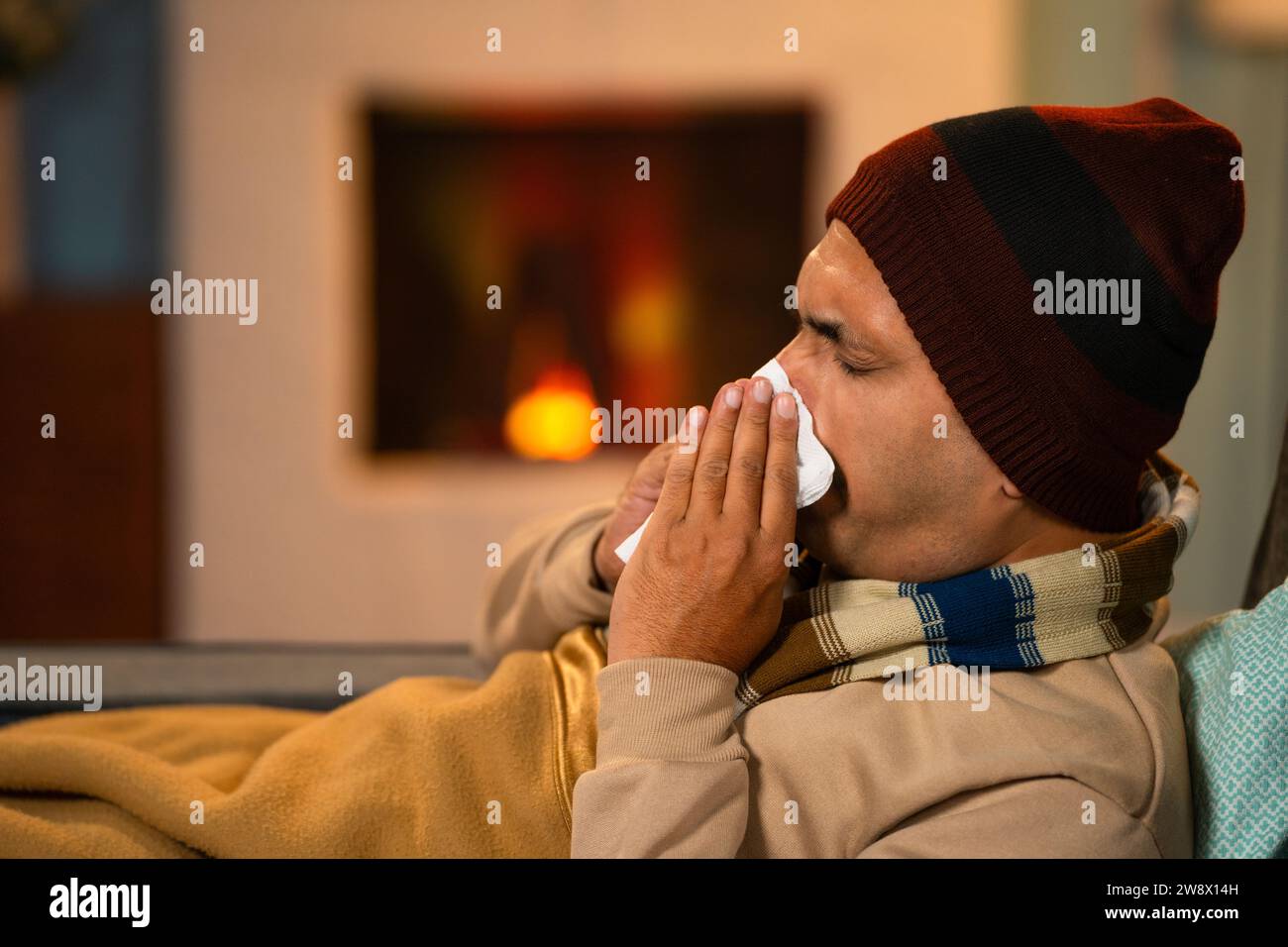 Sick man sneezing due to cold or viral fever infection during winter at ...