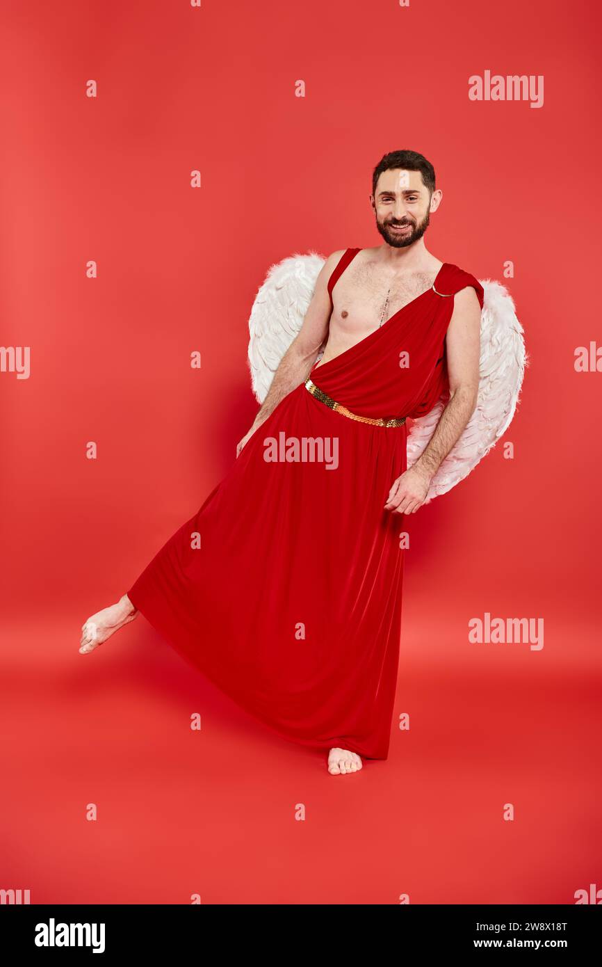 bearded man in cupid costume and wings standing in theatrical pose on ...