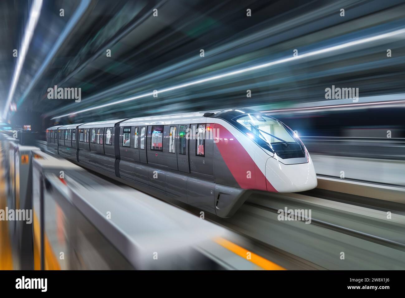 Modern high speed monorail train with bright headlights passes through the station Stock Photo ...