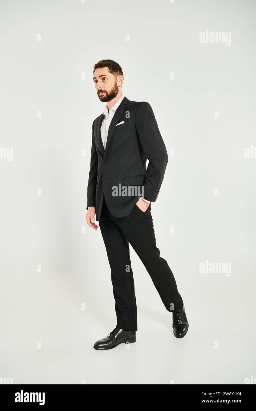 full length of wealthy businessman in black elegant suit posing with ...