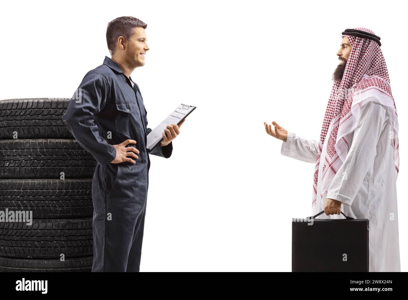 Profile shot of an auto mechanic and a male arab customer talking ...