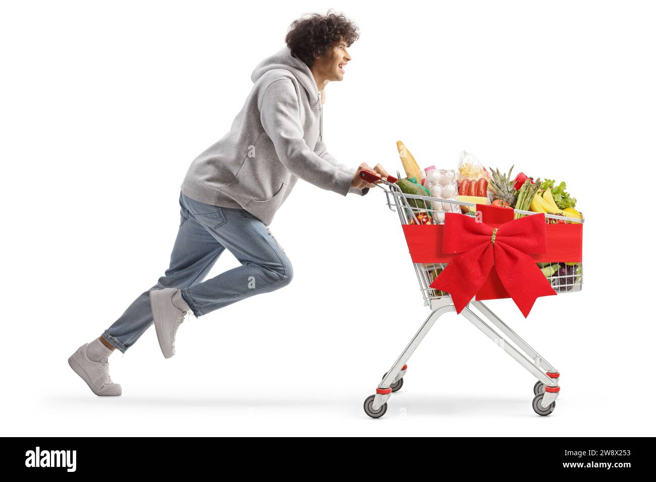 Young man running with christmas food in a shopping cart isolated on ...
