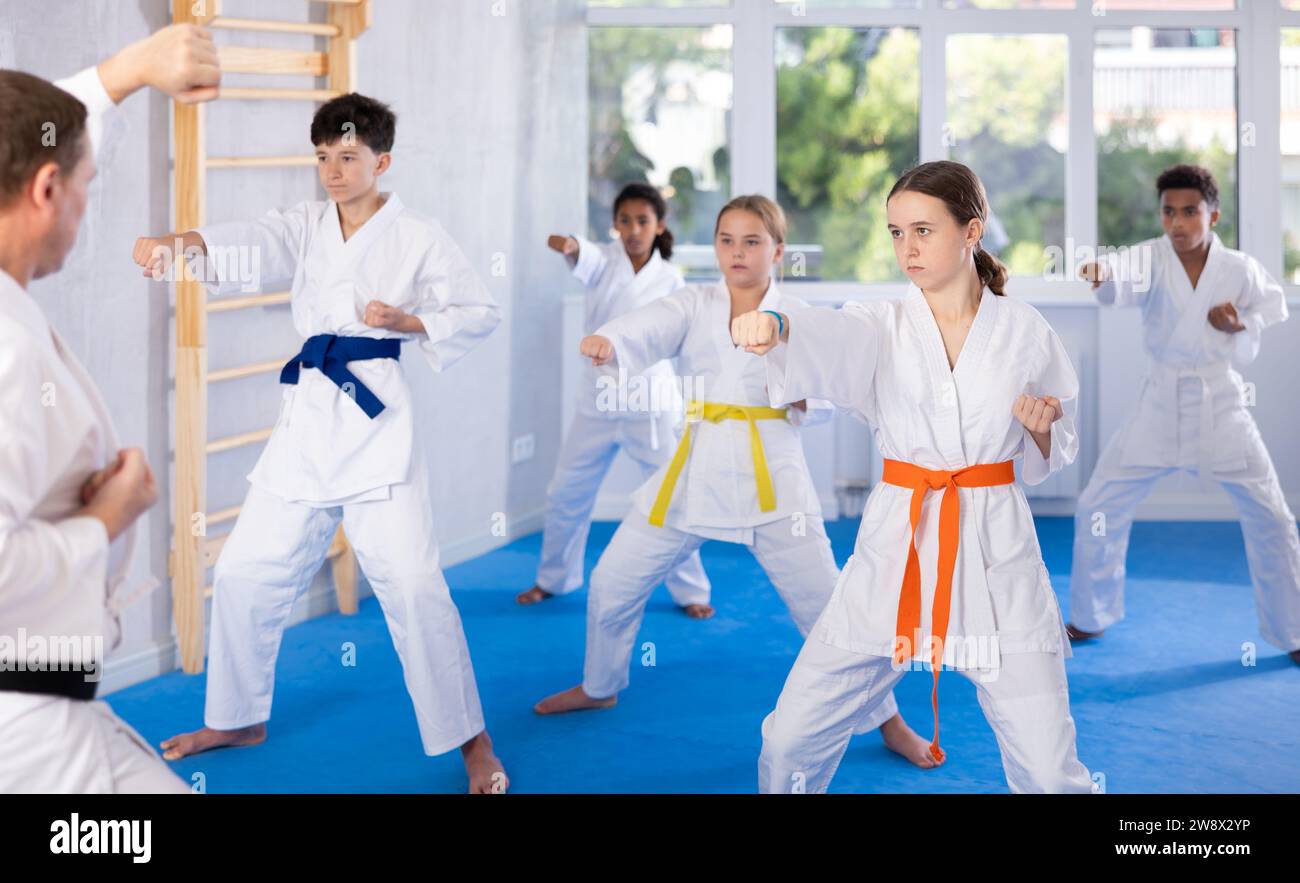 Girl with group of tweens performing kata routines during karate ...