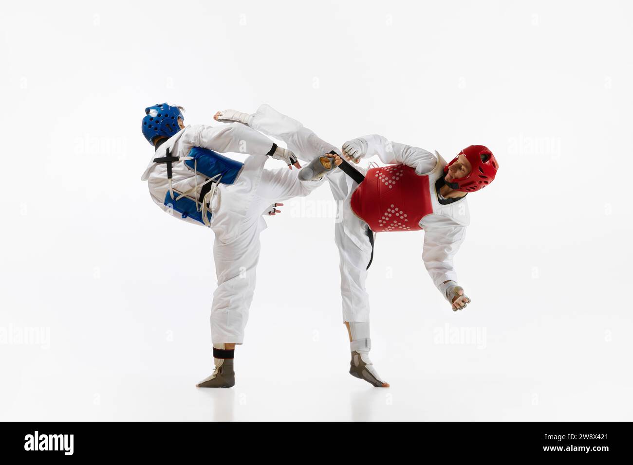 Two men in kimono and helmets practicing taekwondo, training, fighting ...