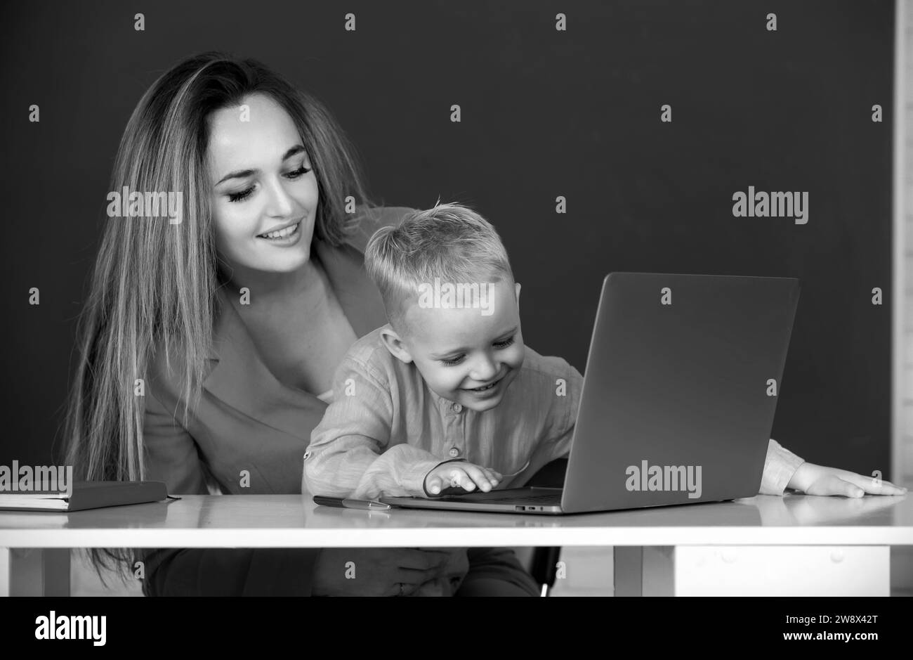 School child using laptop. Elementary school teacher and pupil in ...