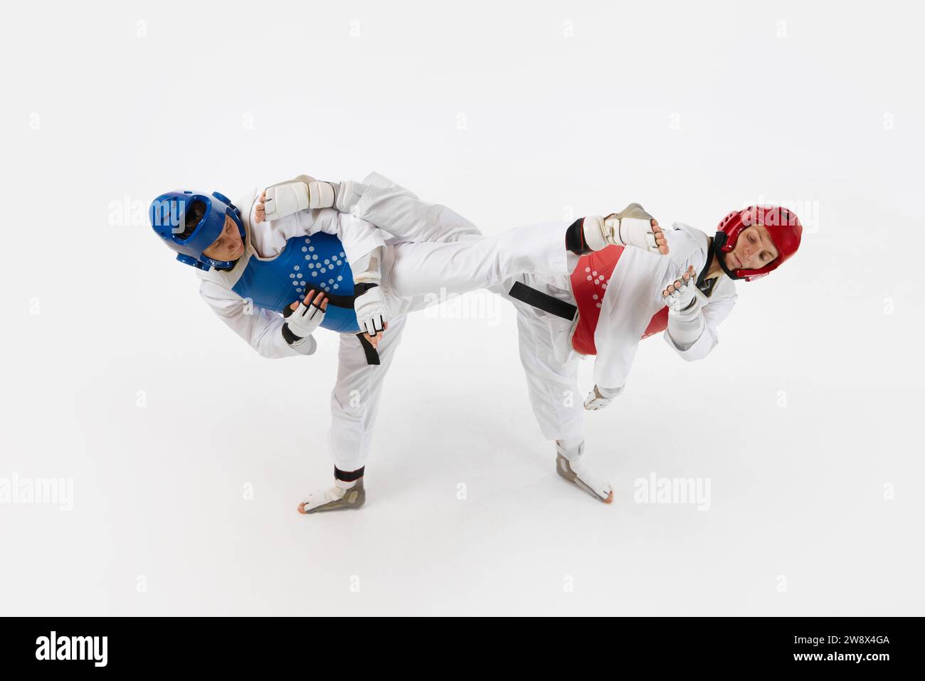 Competitive young men, taekwondo athletes fighting, hitting with legs ...