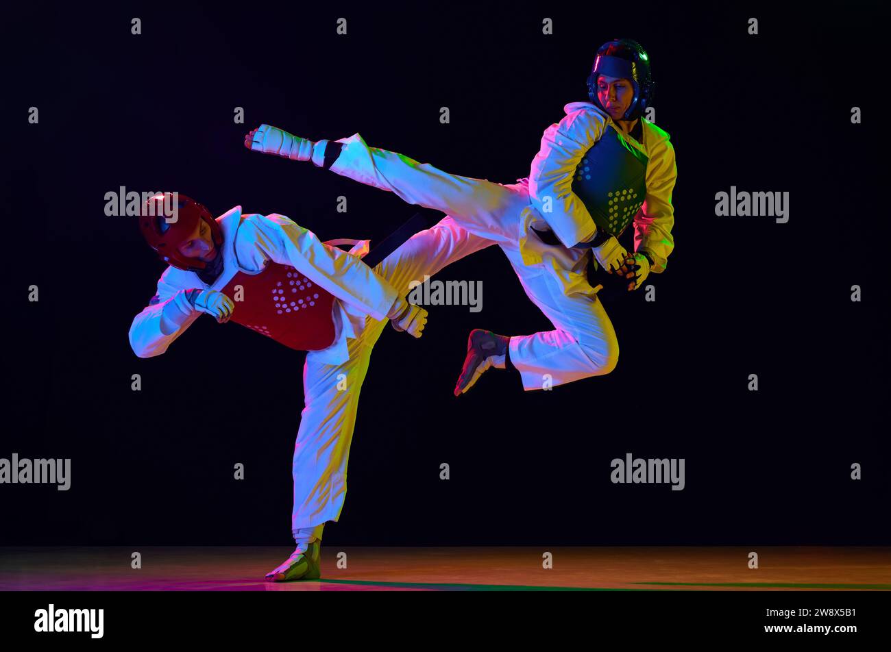 Dynamic image of young men, taekwondo athletes in kimono and helmets ...