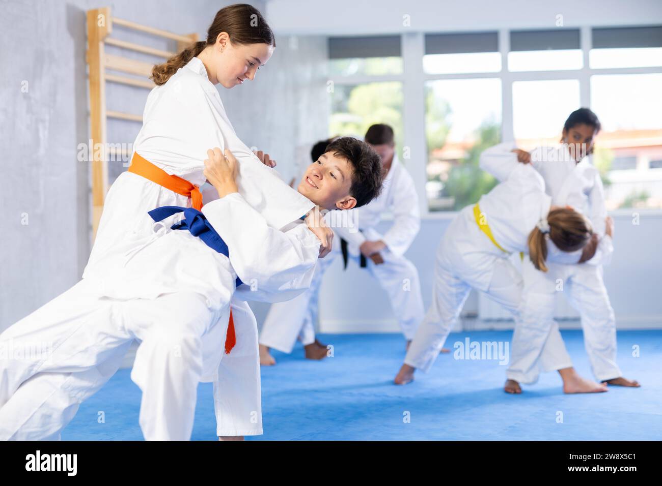 Girls and boys judo fighters in sport hall. Martial arts under the ...