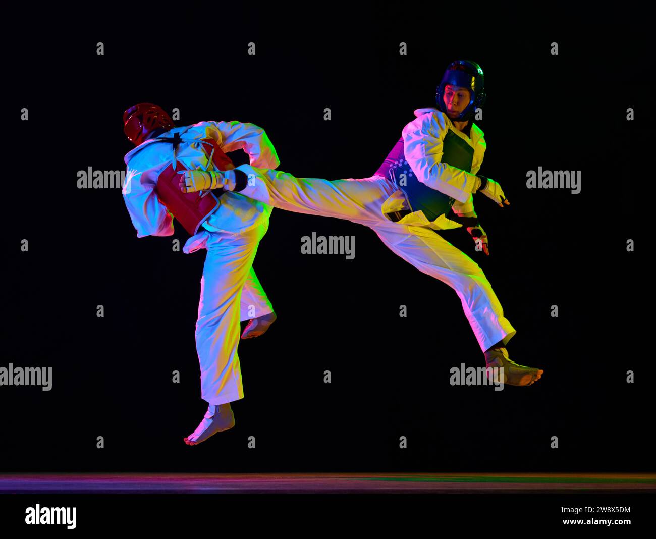 Dynamic image of young men, taekwondo athletes in kimono and helmets ...