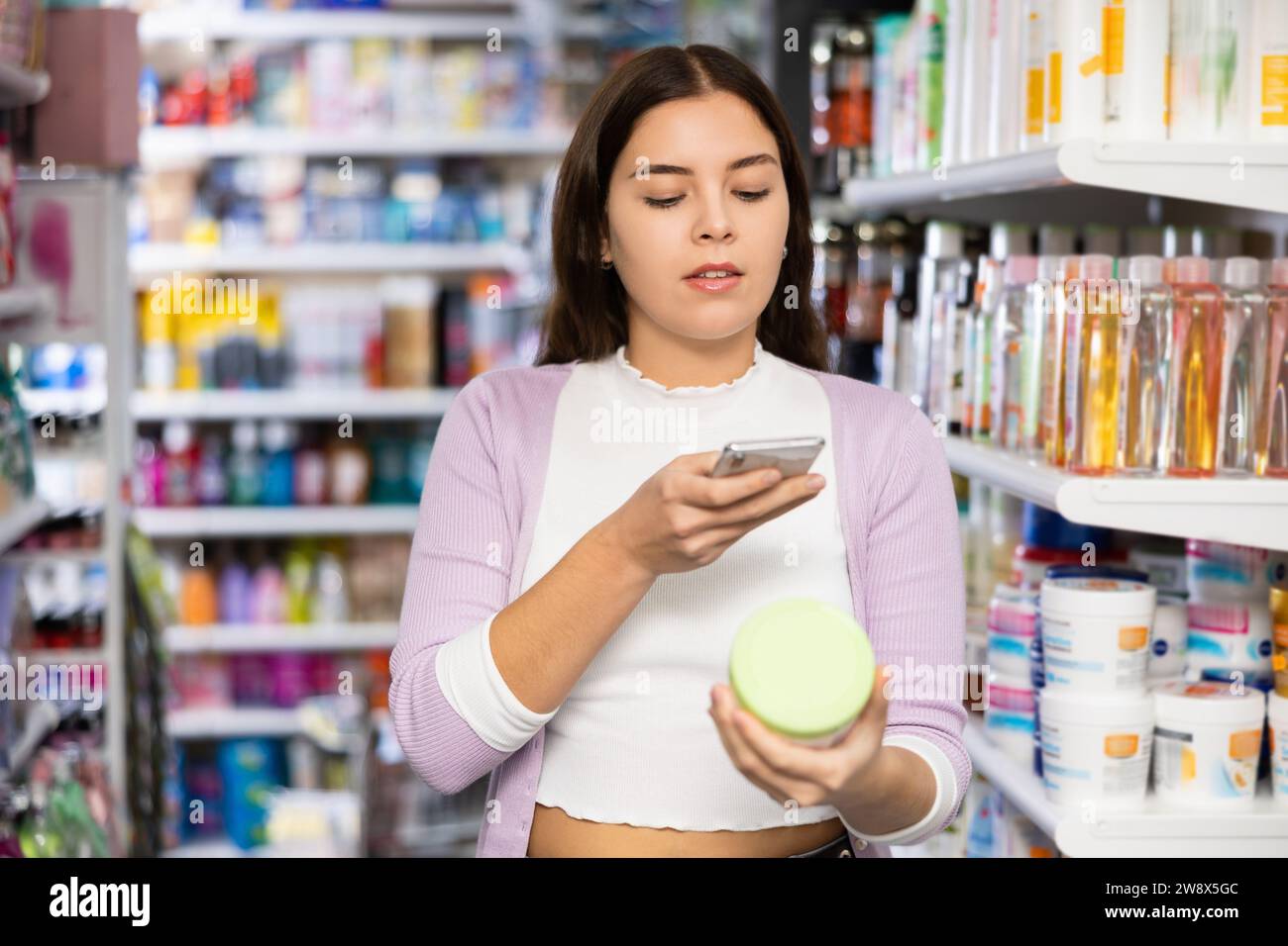 Female customer takes a photo using a mobile phone in cosmetics store ... Female customer takes a photo using a mobile phone in cosmetics store ...