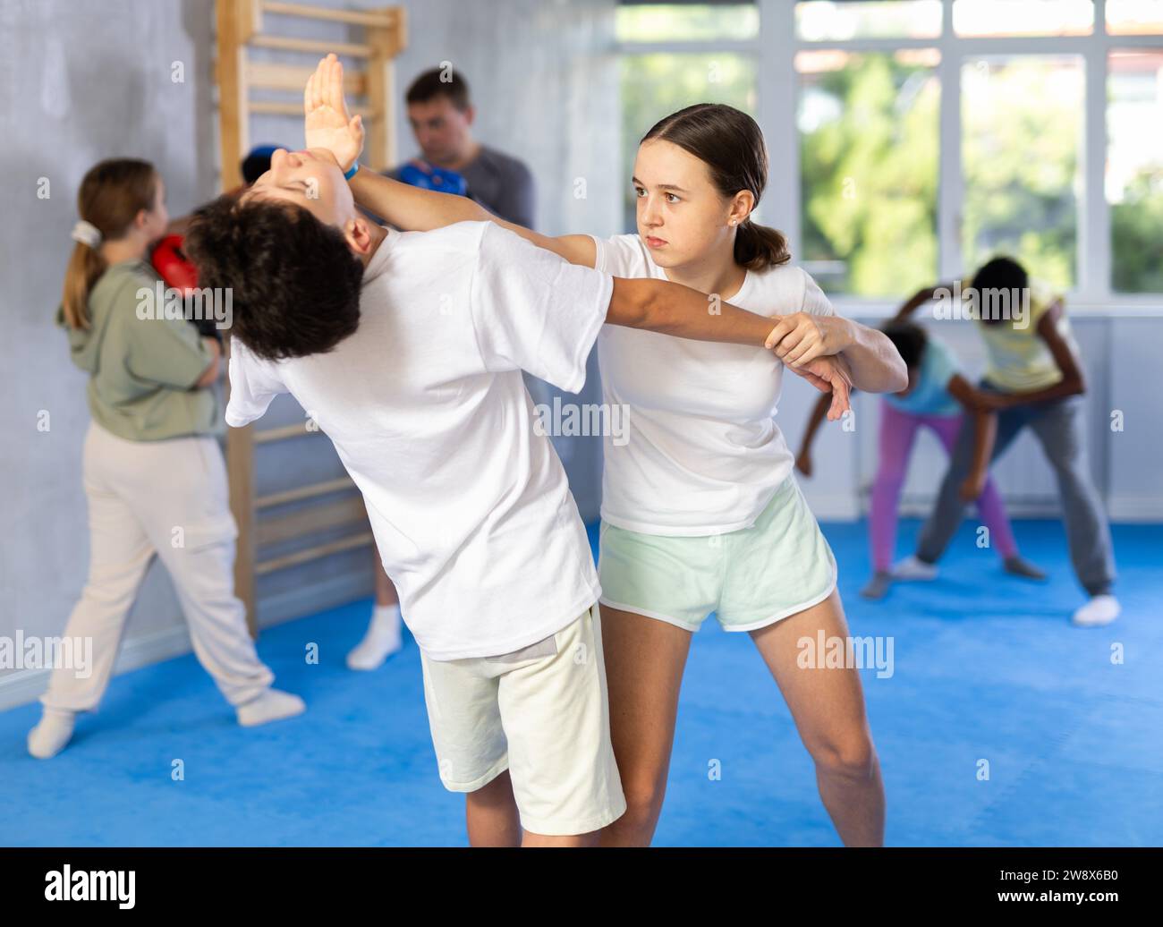 Preteen children pairs learning strength self-defense in gym Stock ...