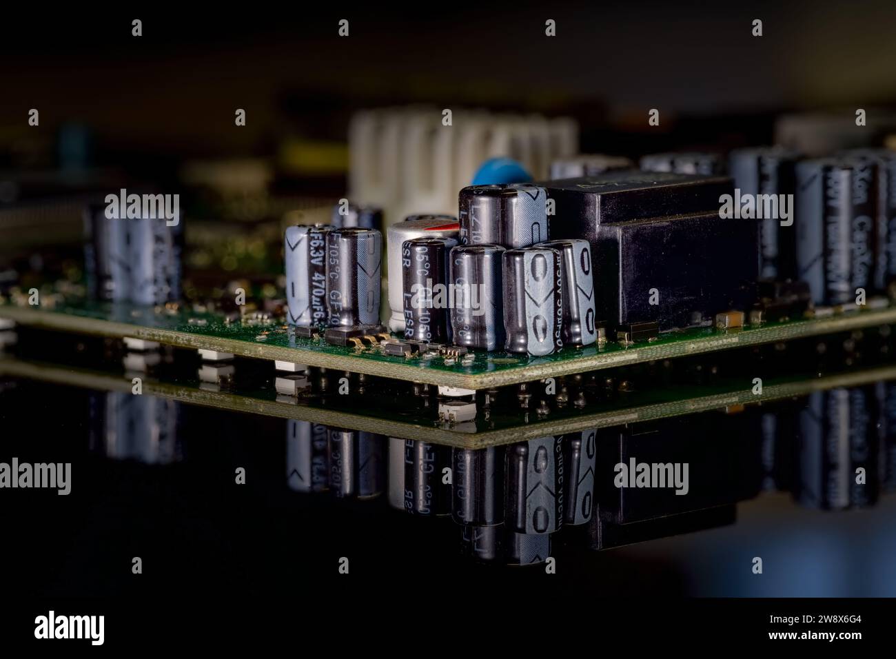Close-up of a computer mainboard with transistors and electrolytic ...