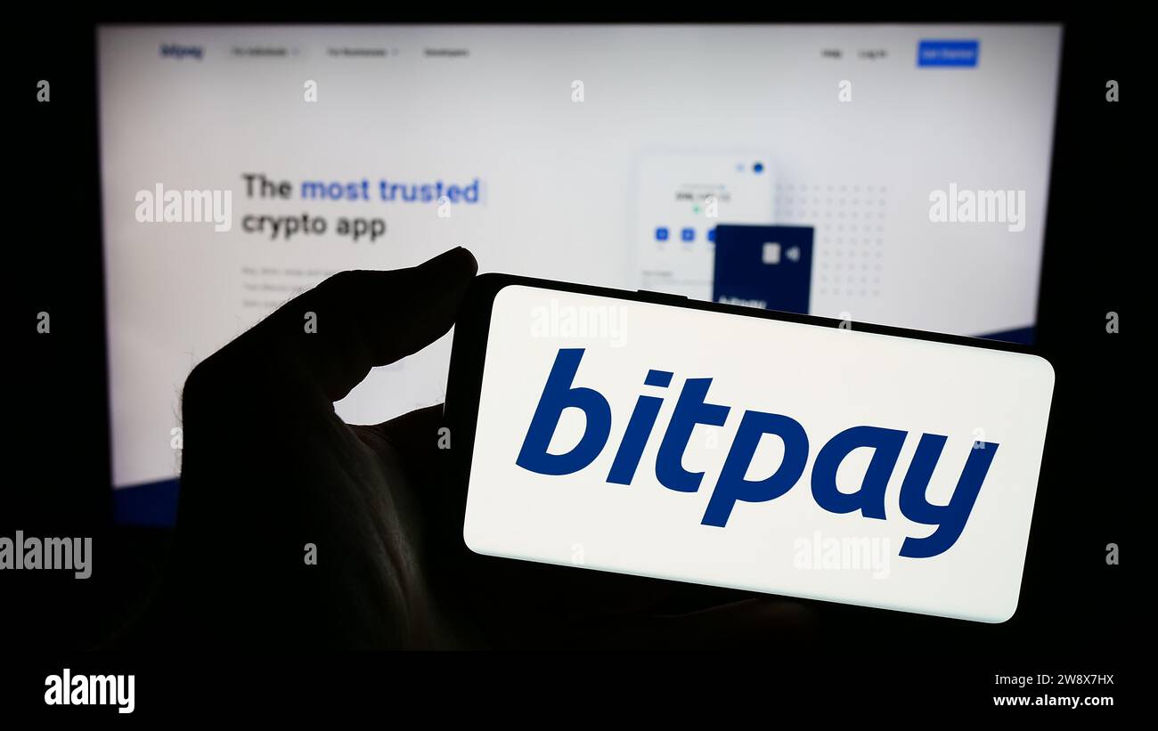 Person holding smartphone with logo of US cryptocurrency payment ...