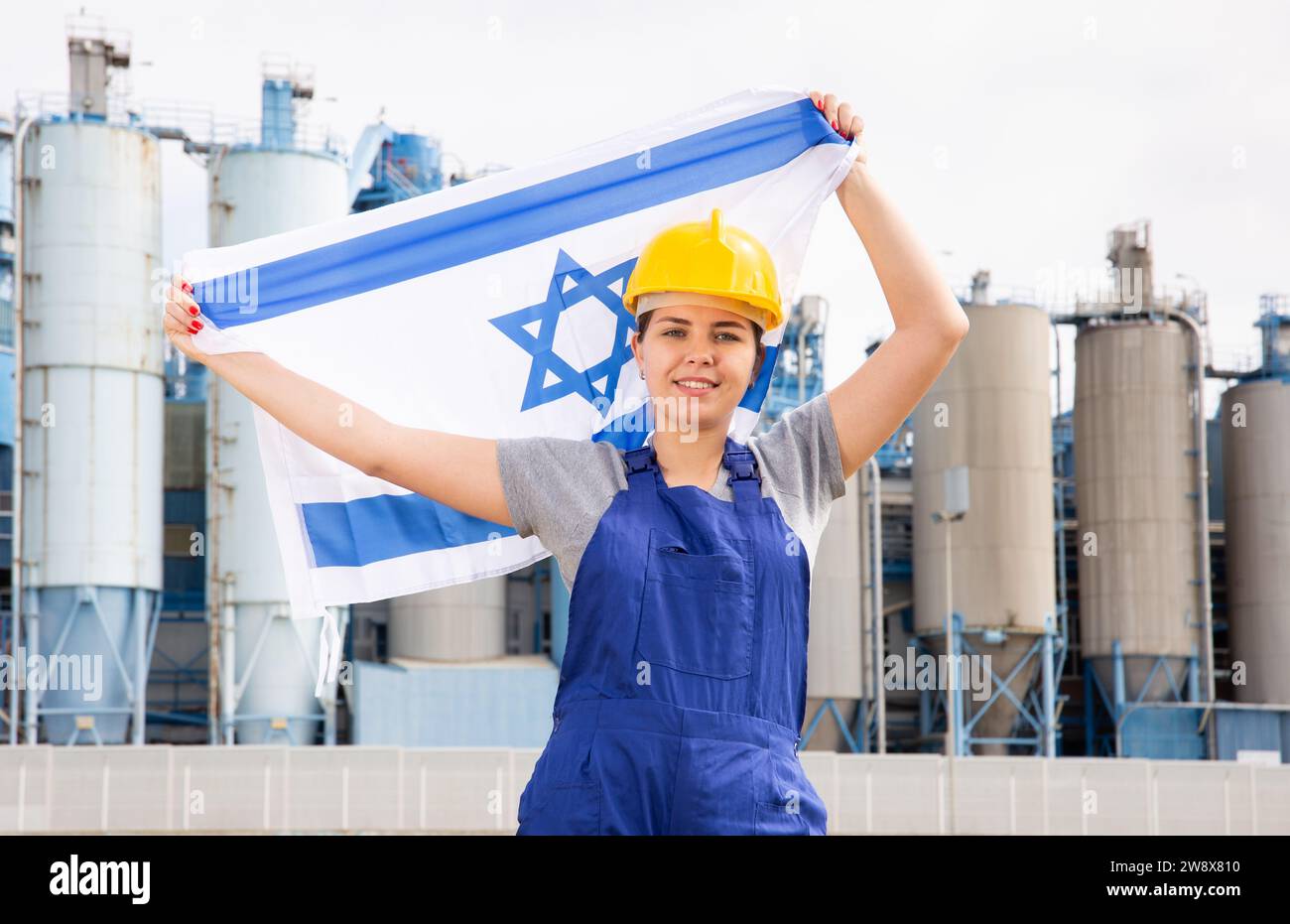 National flag of Israel in the hands of girl in overalls against ...