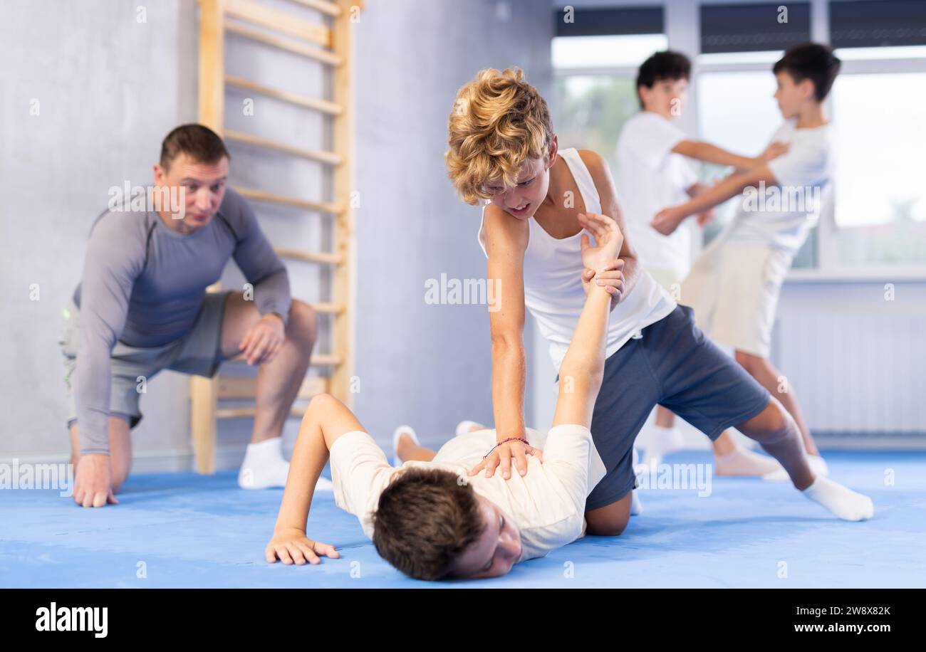 Teenagers practicing painful armlock in sparring during self defence ...