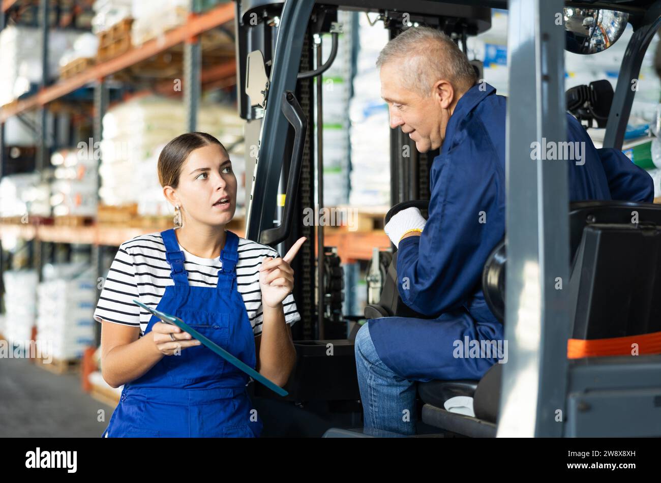 Young woman and elderly man working on loader check documents Stock ...