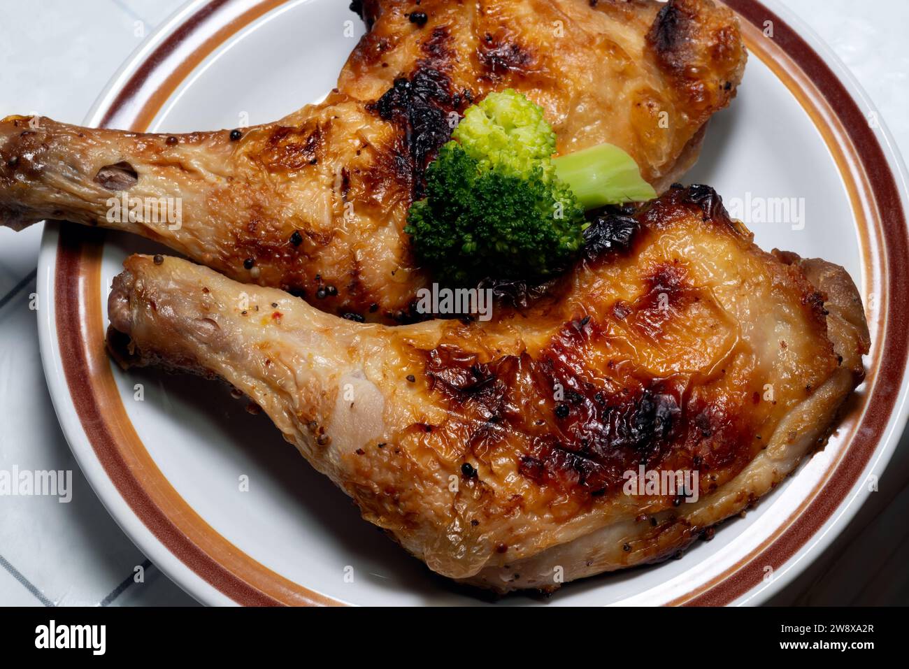 Grilled chicken legs on a plate close up shot Stock Photo - Alamy