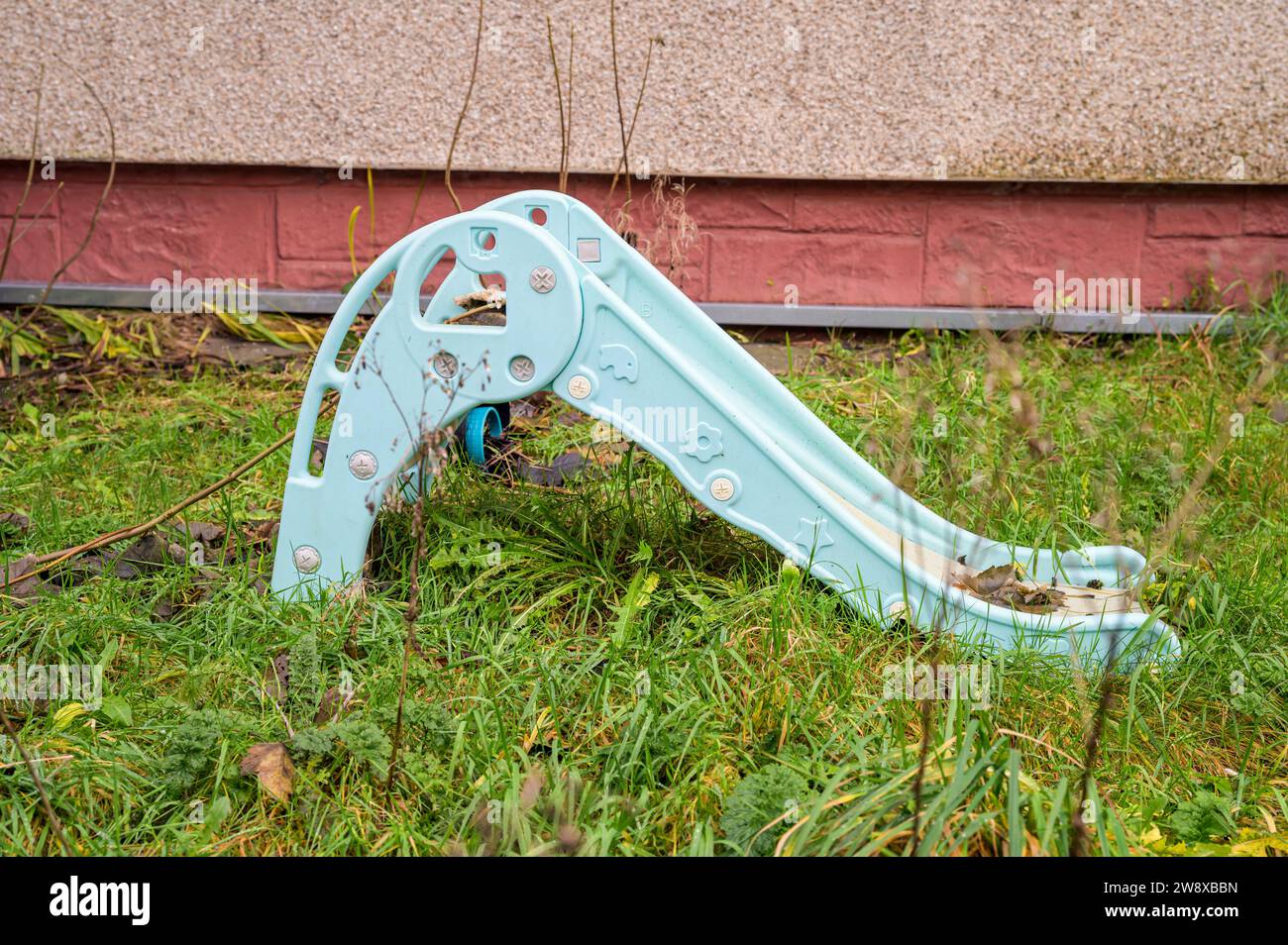 Abandoned childs garden slide Stock Photo - Alamy