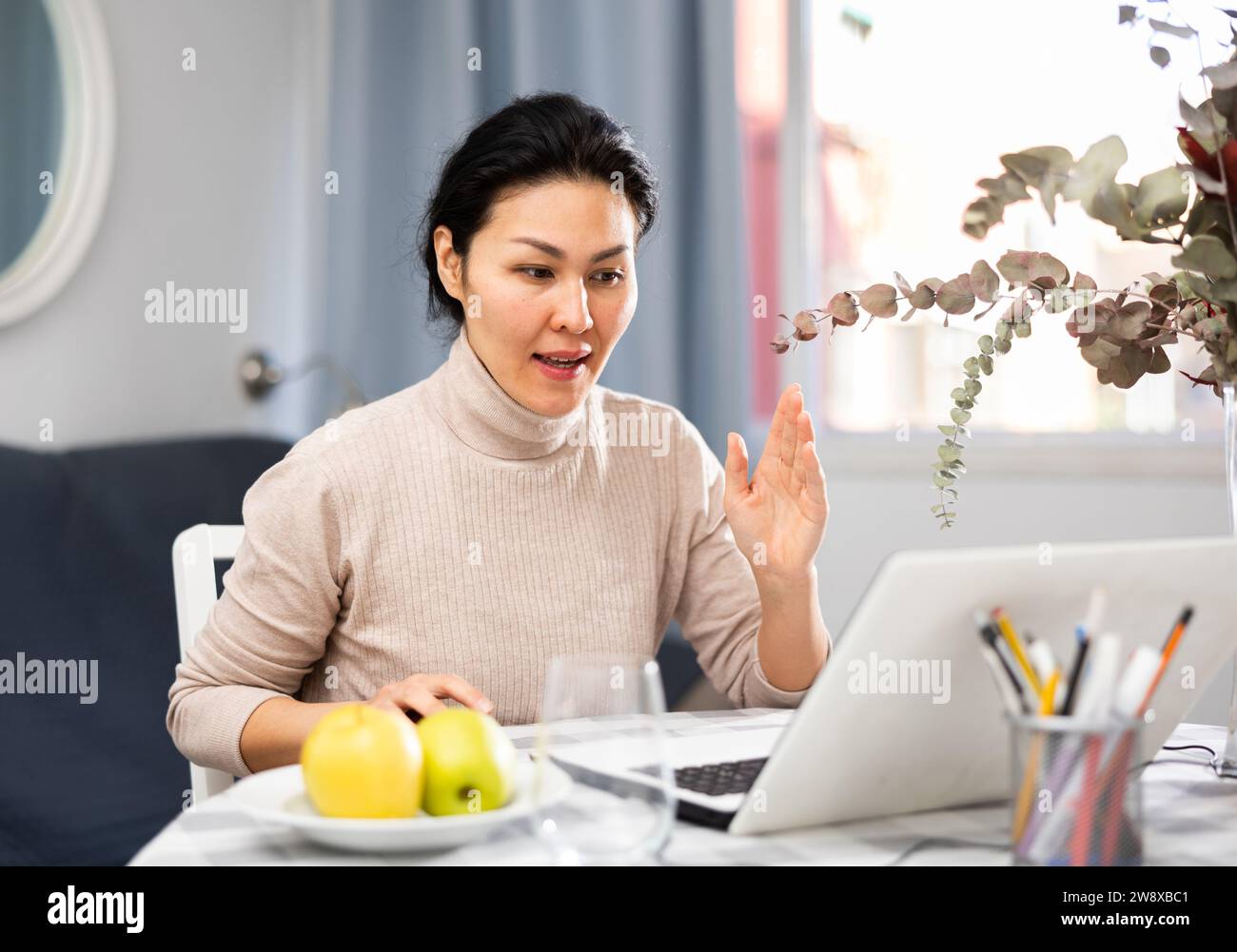 Woman having video call conversation at home Stock Photo - Alamy