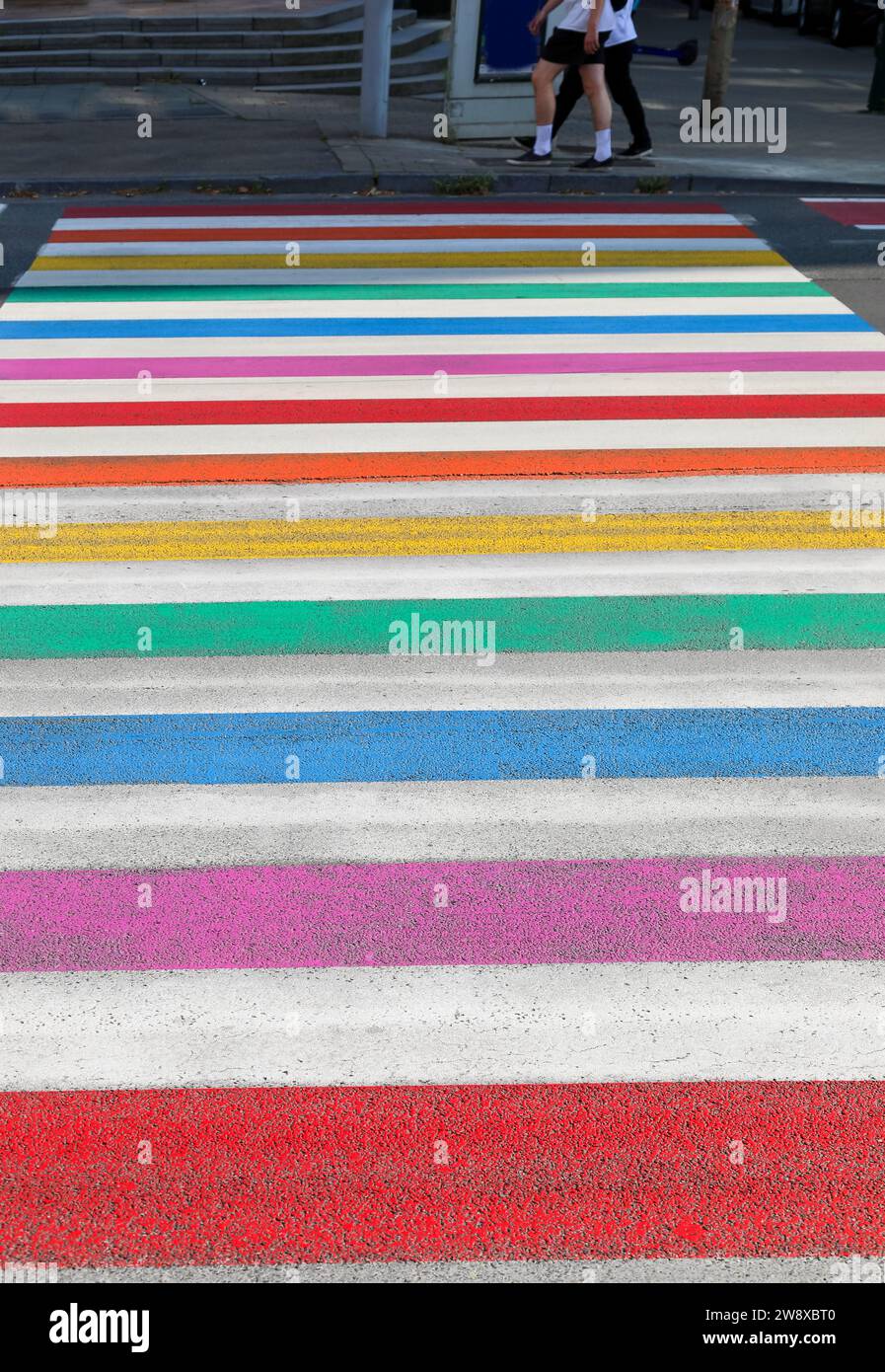 large pedestrian crossing with many lines of rainbow colors in the city ...