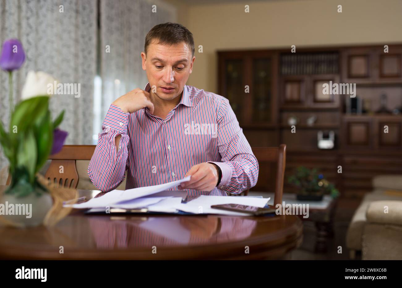 Concentrated man filling out papers Stock Photo - Alamy