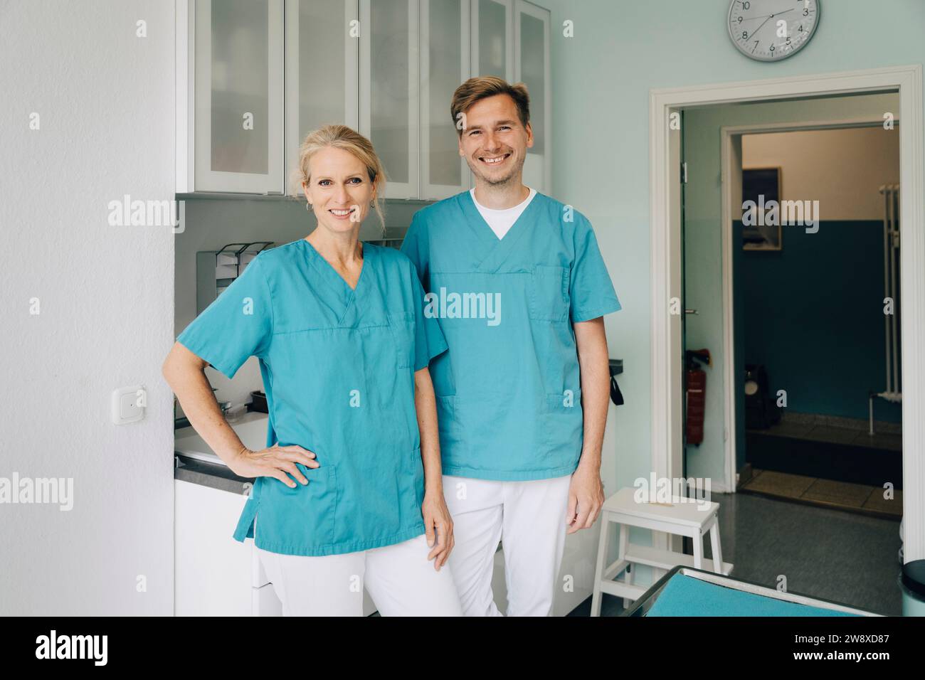 Portrait of smiling male and female animal experts standing in clinic ...