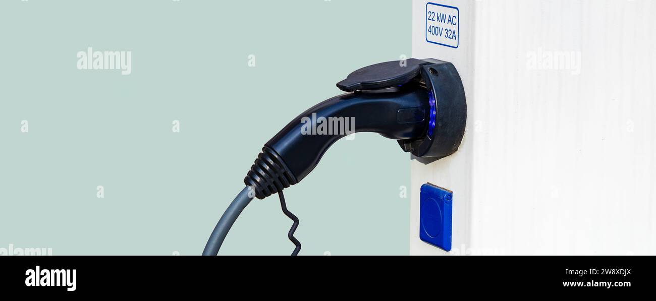 Closeup of charger plug to an electric vehicle from charging station ...