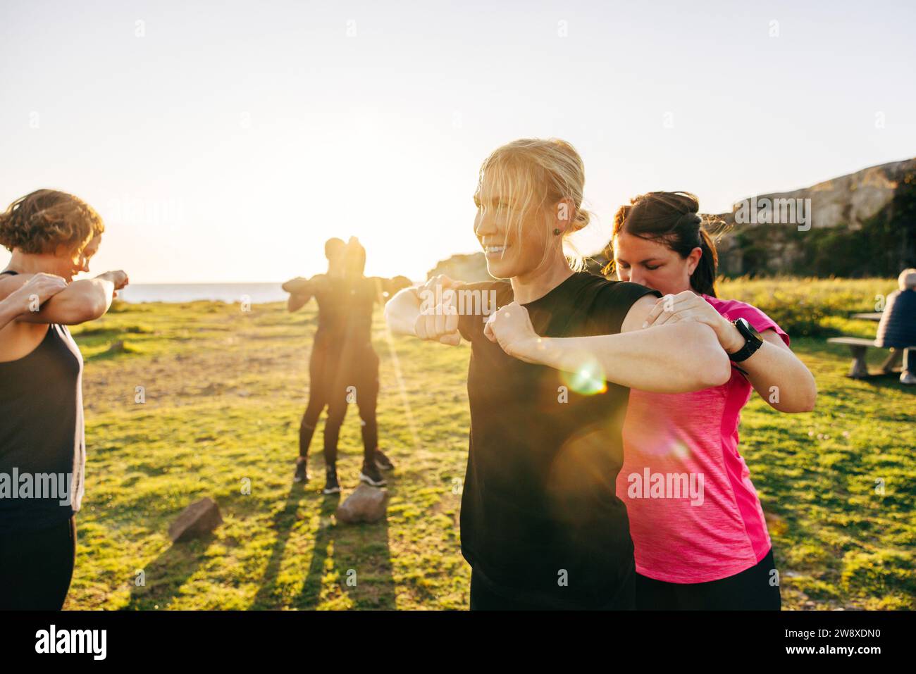 Team assisting each other during group training session at beach Stock ...