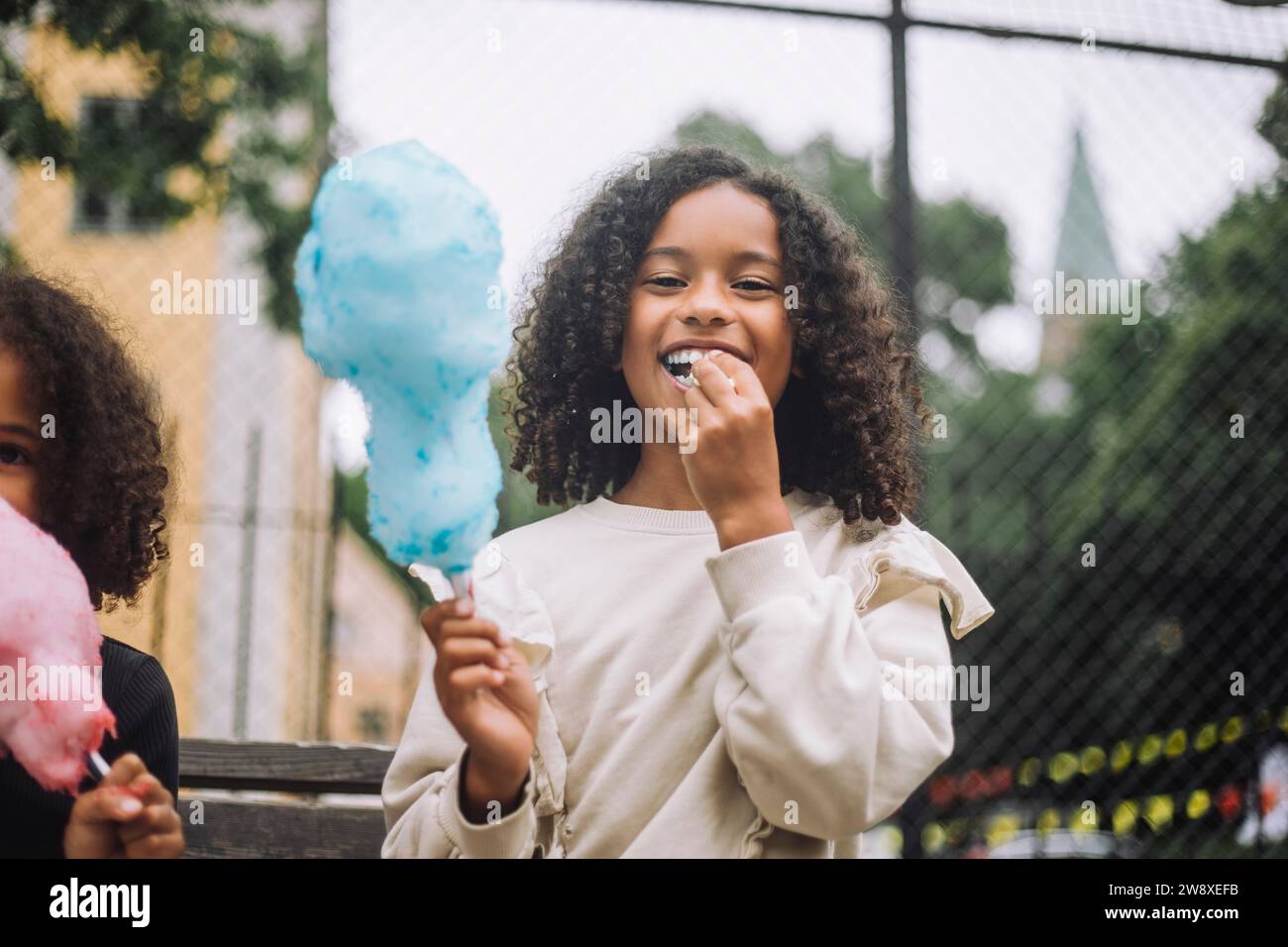 Portrait of girl eating popcorn at amusement park Stock Photo - Alamy