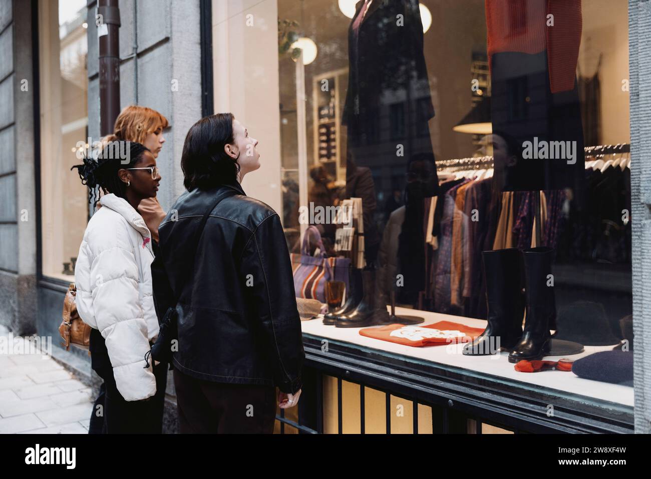 Multiracial female friends doing window shopping while standing at ...