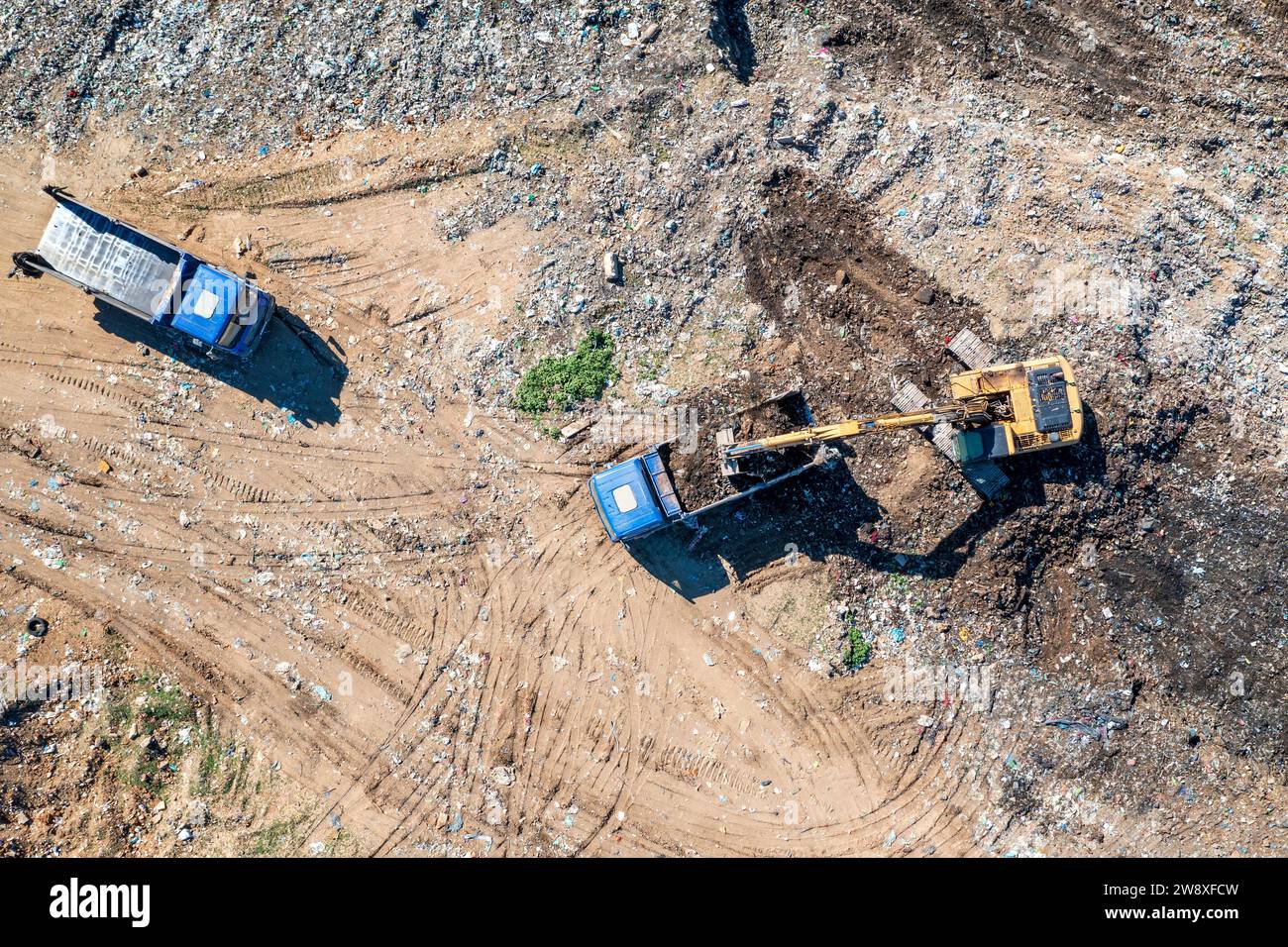 Aerial top view of excavator and dump trucks working at the ...