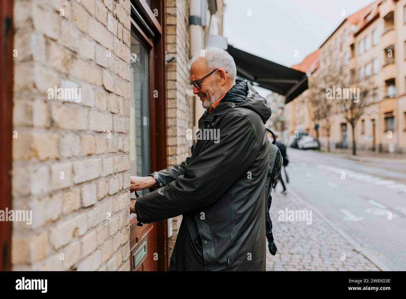 Side view of senior male entrepreneur closing door of antique shop ...