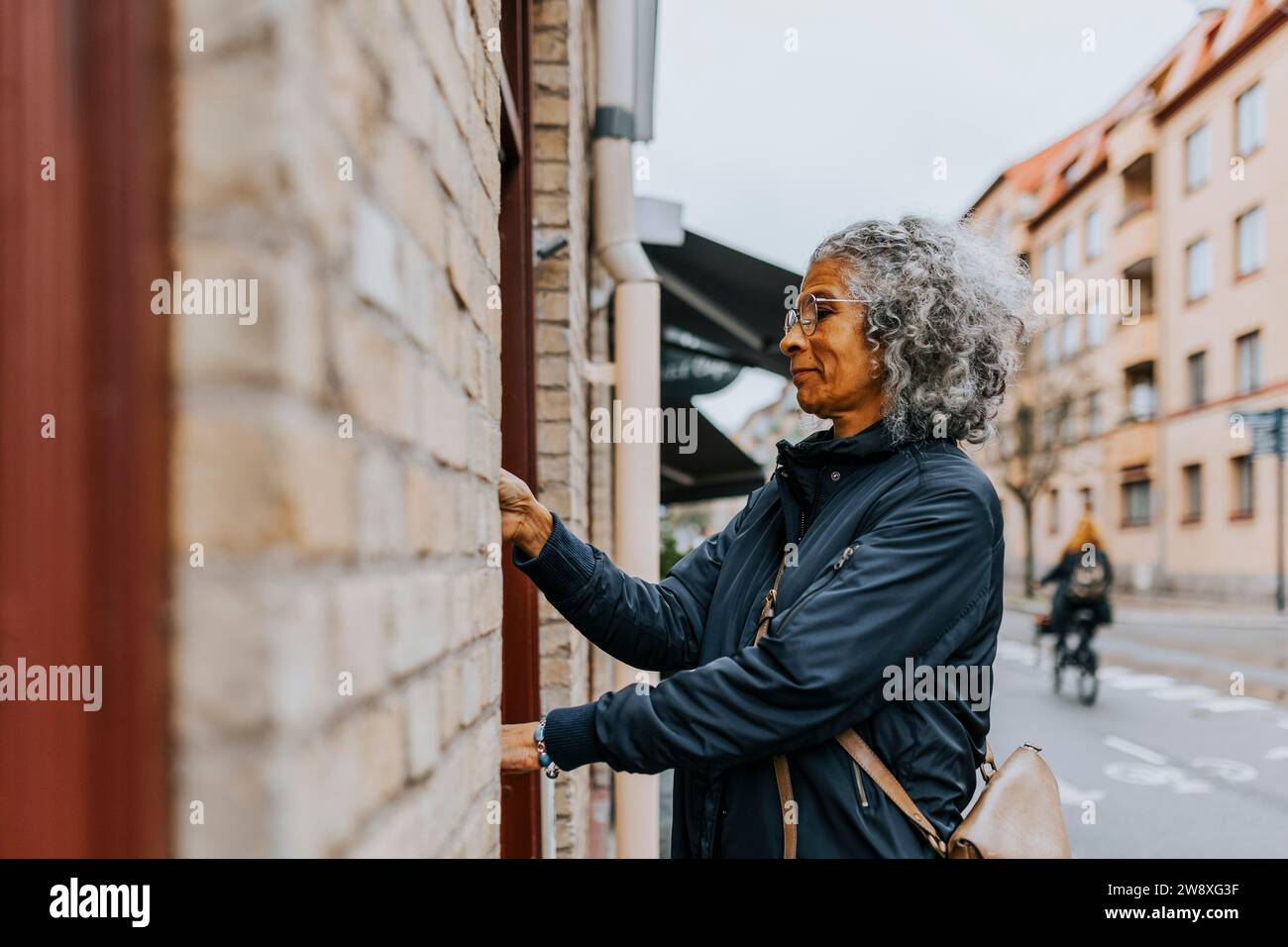 Side view of senior female entrepreneur closing door of antique shop ...