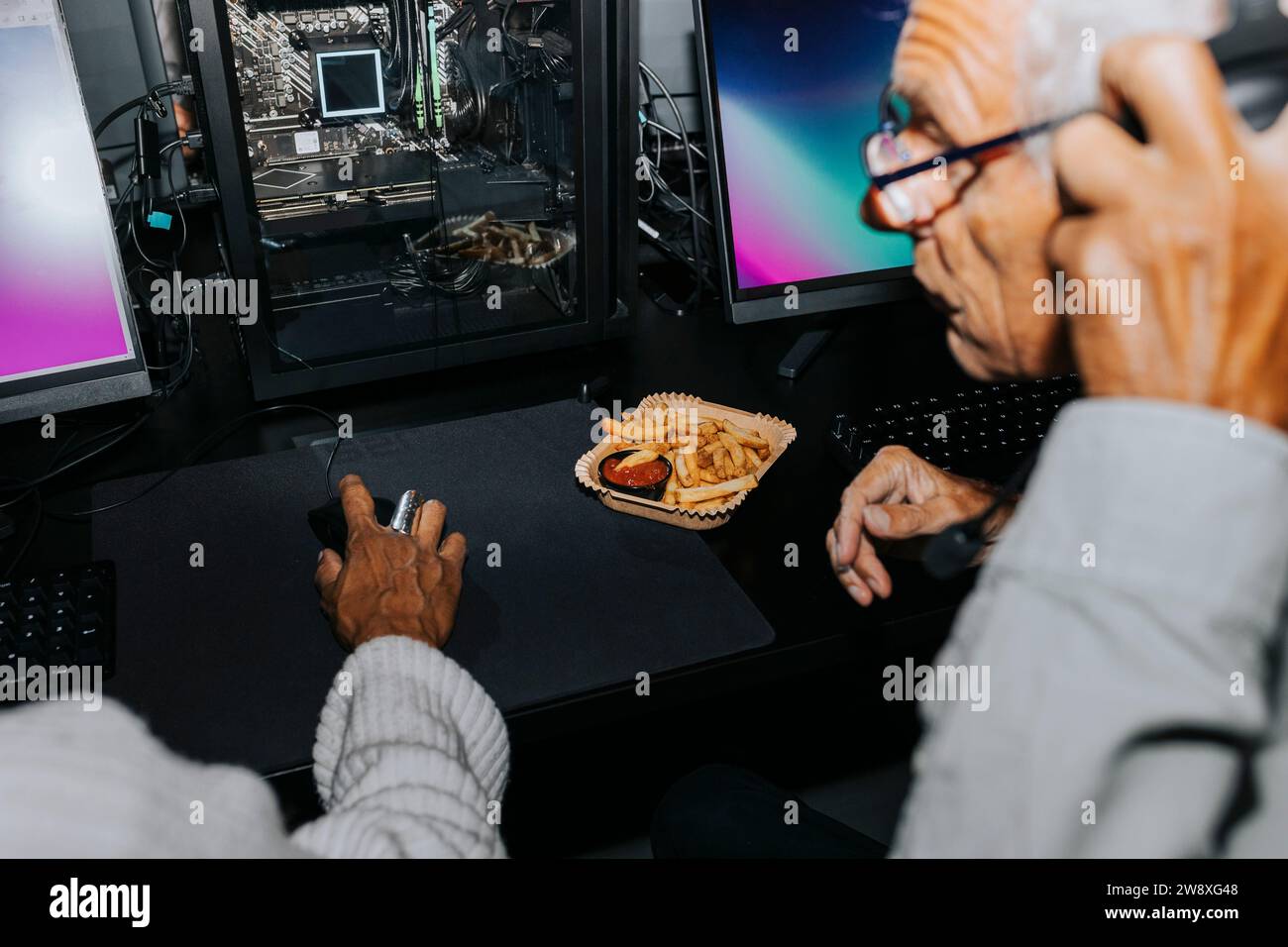 Elderly female and male friends playing computer game together at ...