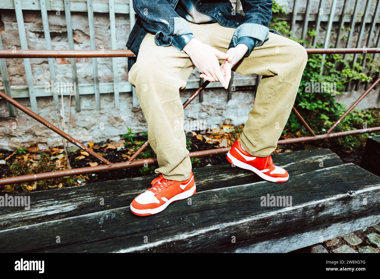 Low section of boy sitting on railing Stock Photo - Alamy