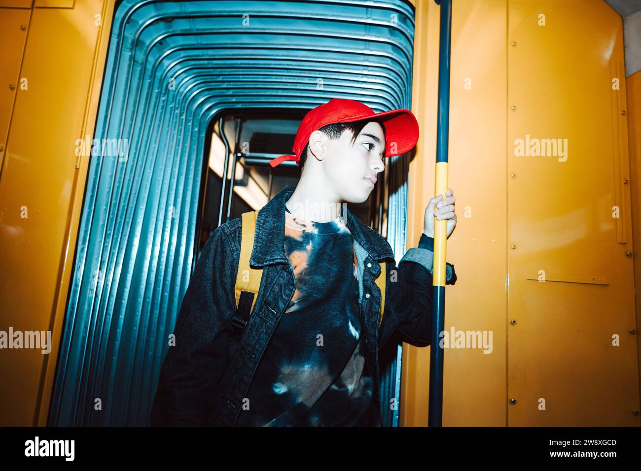 Contemplative boy wearing cap standing at doorway of tram Stock Photo ...