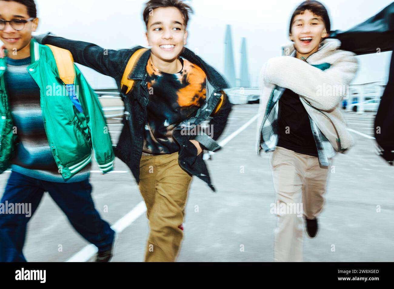 Happy male friends running on street while enjoying weekend Stock Photo ...
