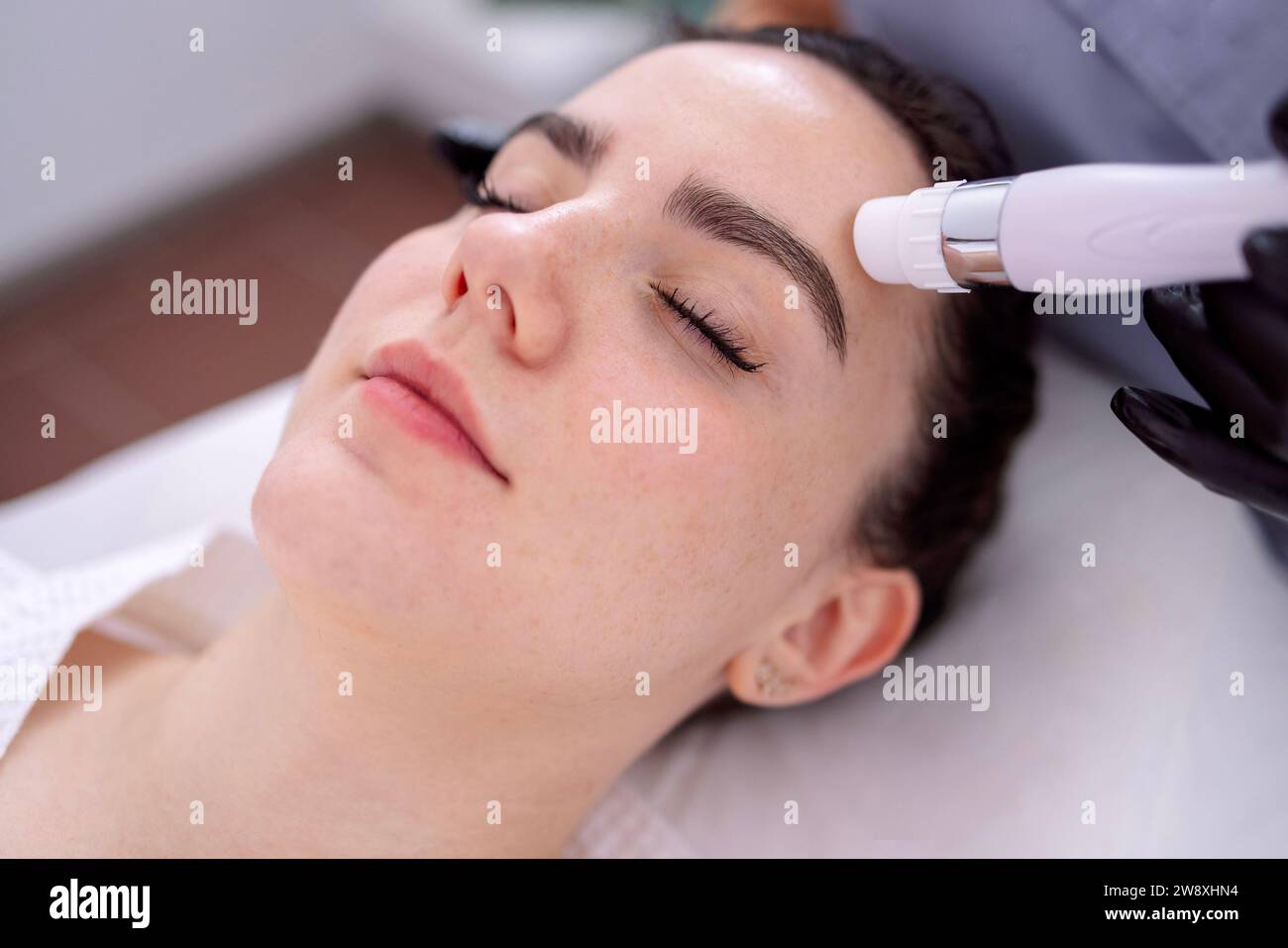 Rejuvenating facial therapy treatment at spa salon clinic. Young ...