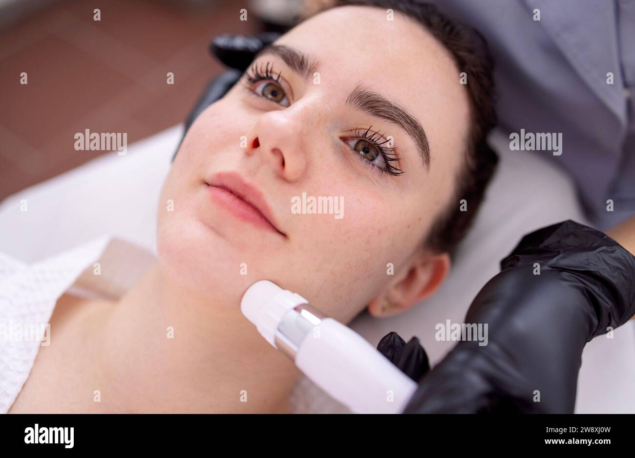 Rejuvenating facial therapy treatment at spa salon clinic. Young ...