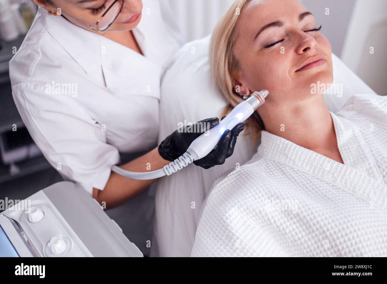 Rejuvenating facial therapy treatment at spa salon clinic. Young ...