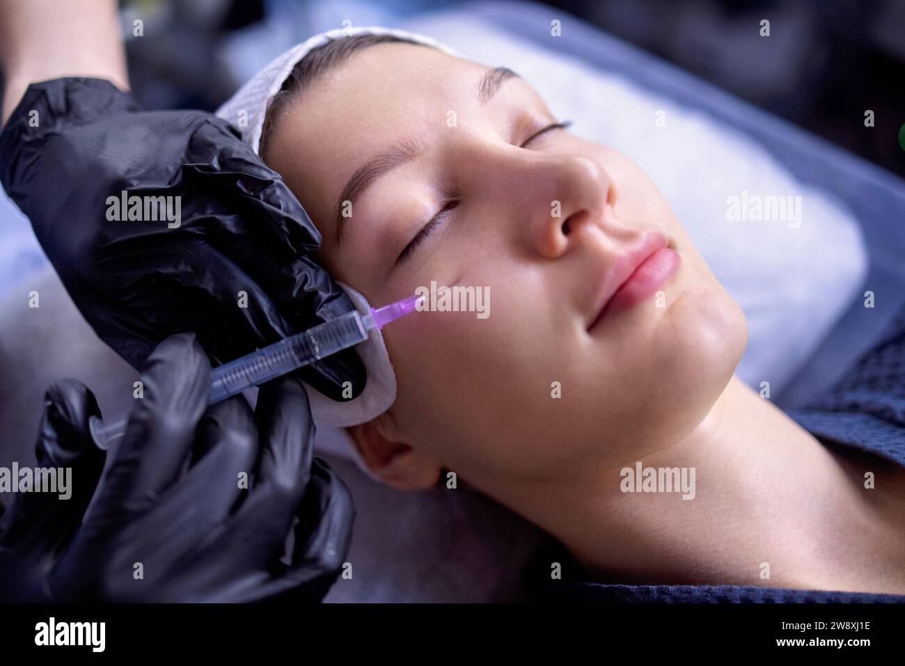 Beauty injections. Female cosmetologist in black gloves makes an ...
