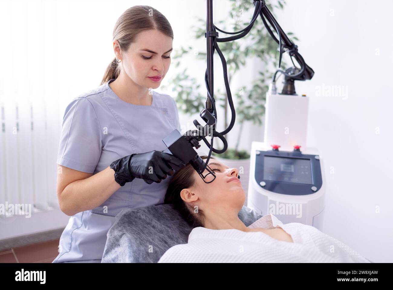 Closeup of the face of young woman undergoing laser resurfacing and ...