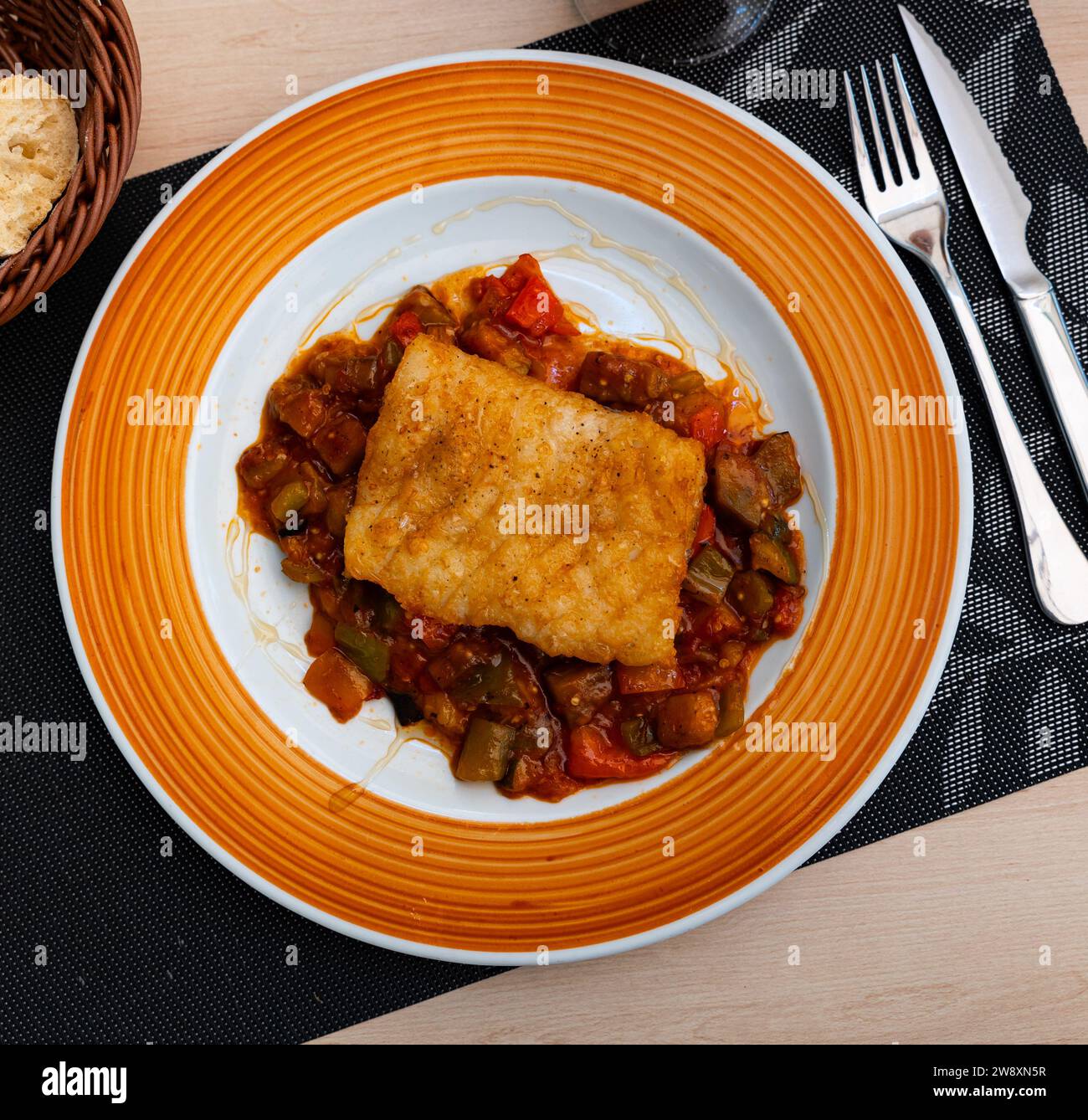 Fried cod fillet served with samfaina Stock Photo - Alamy