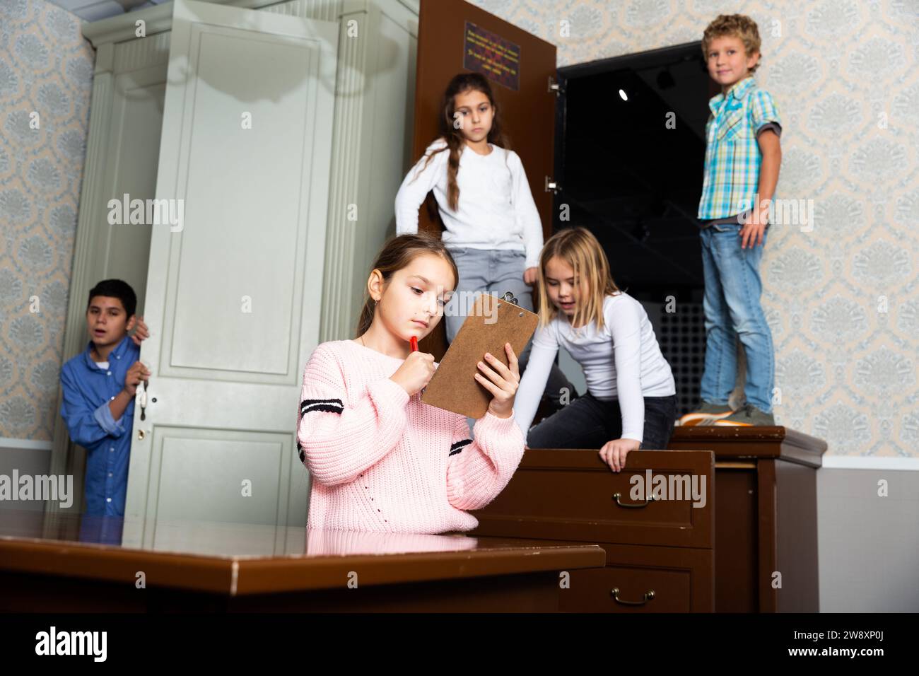 Focused tween girl trying to solve riddles in quest room Stock Photo - Alamy
