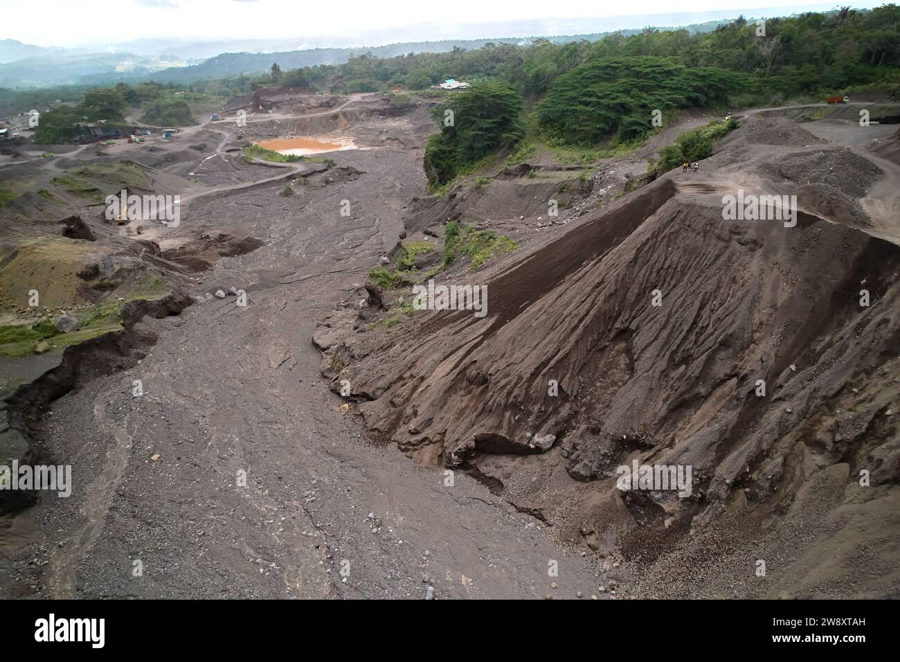 A stone quarry in Indonesia. Large equipment such as bulldozers and ...